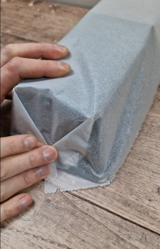 Er faltet Backpapier um eine Backform. Klingt seltsam, ist aber genial ...